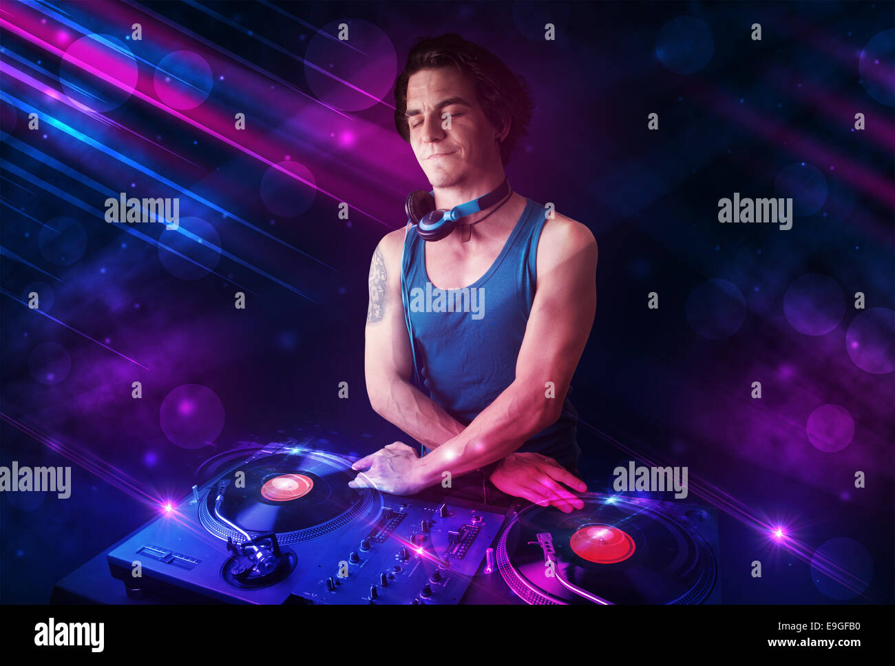 Young DJ playing on turntables with color light effects Stock Photo - Alamy