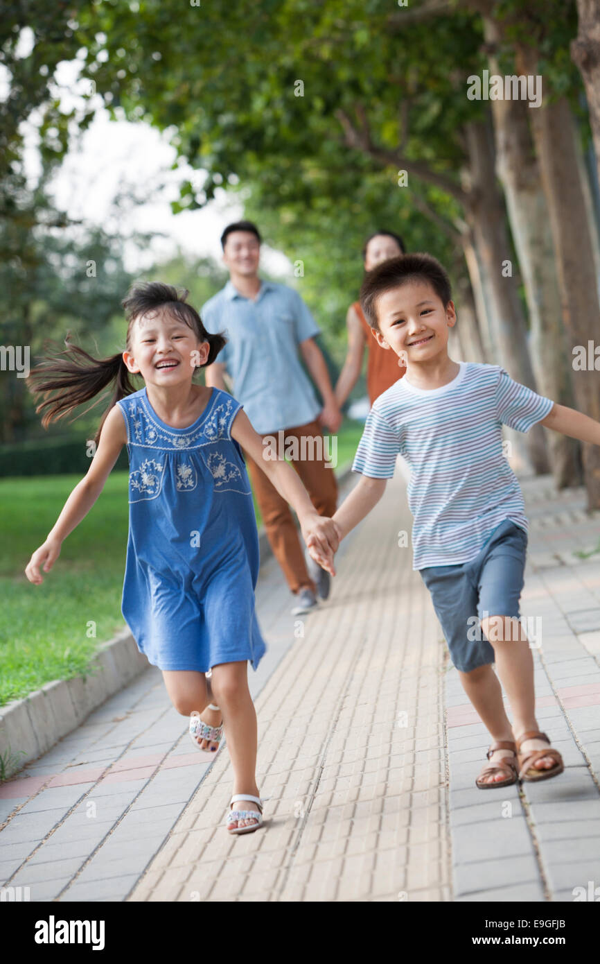 Happy brother and sister holding hands running Stock Photo - Alamy