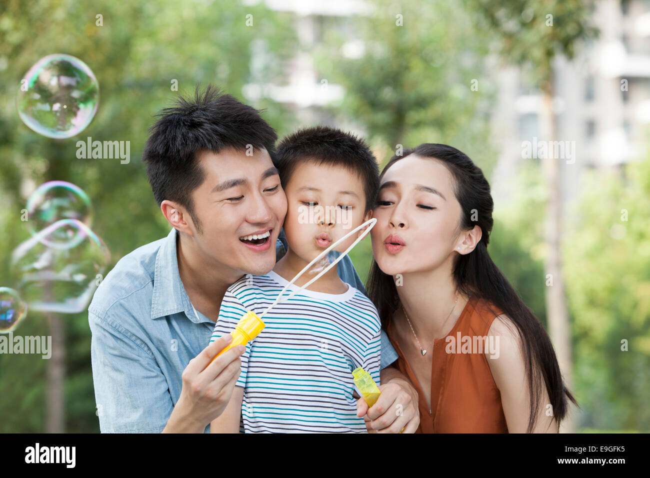 Happy young family blowing bubbles Stock Photo - Alamy