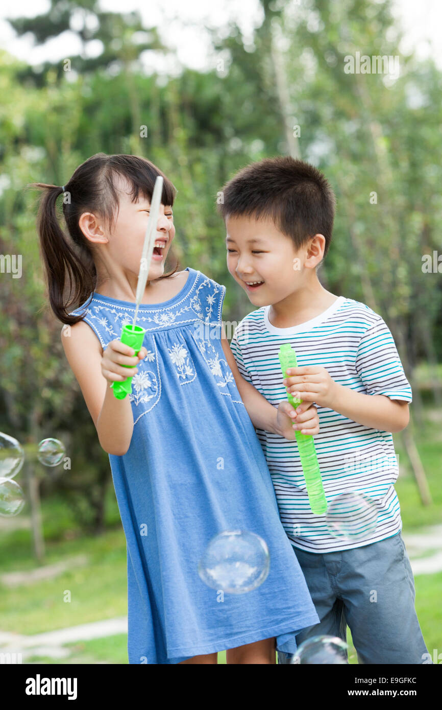 Two children blowing bubbles Stock Photo - Alamy