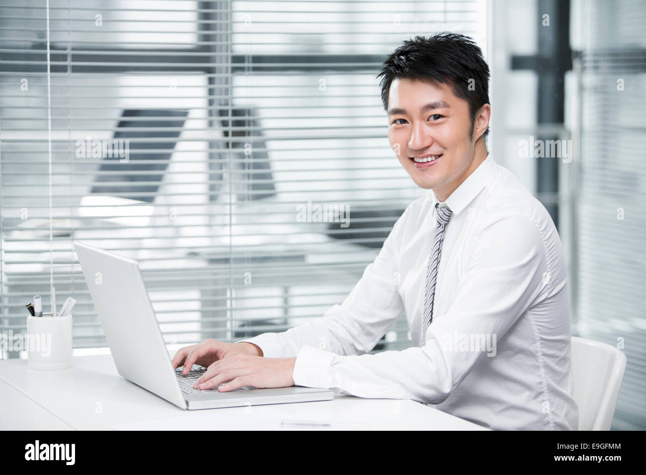 Young businessman using laptop Stock Photo - Alamy