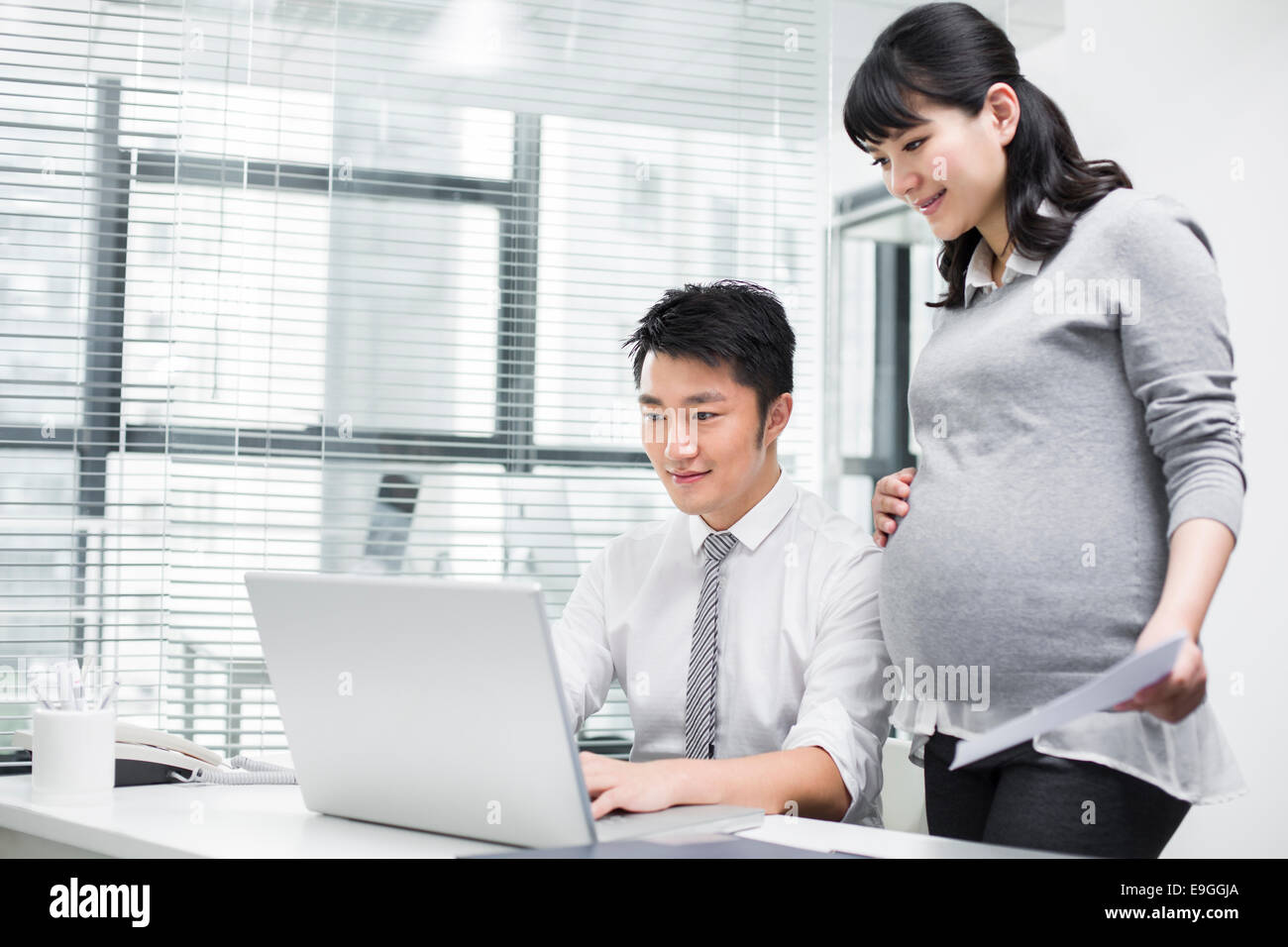 Pregnant businesswoman working with colleague Stock Photo - Alamy