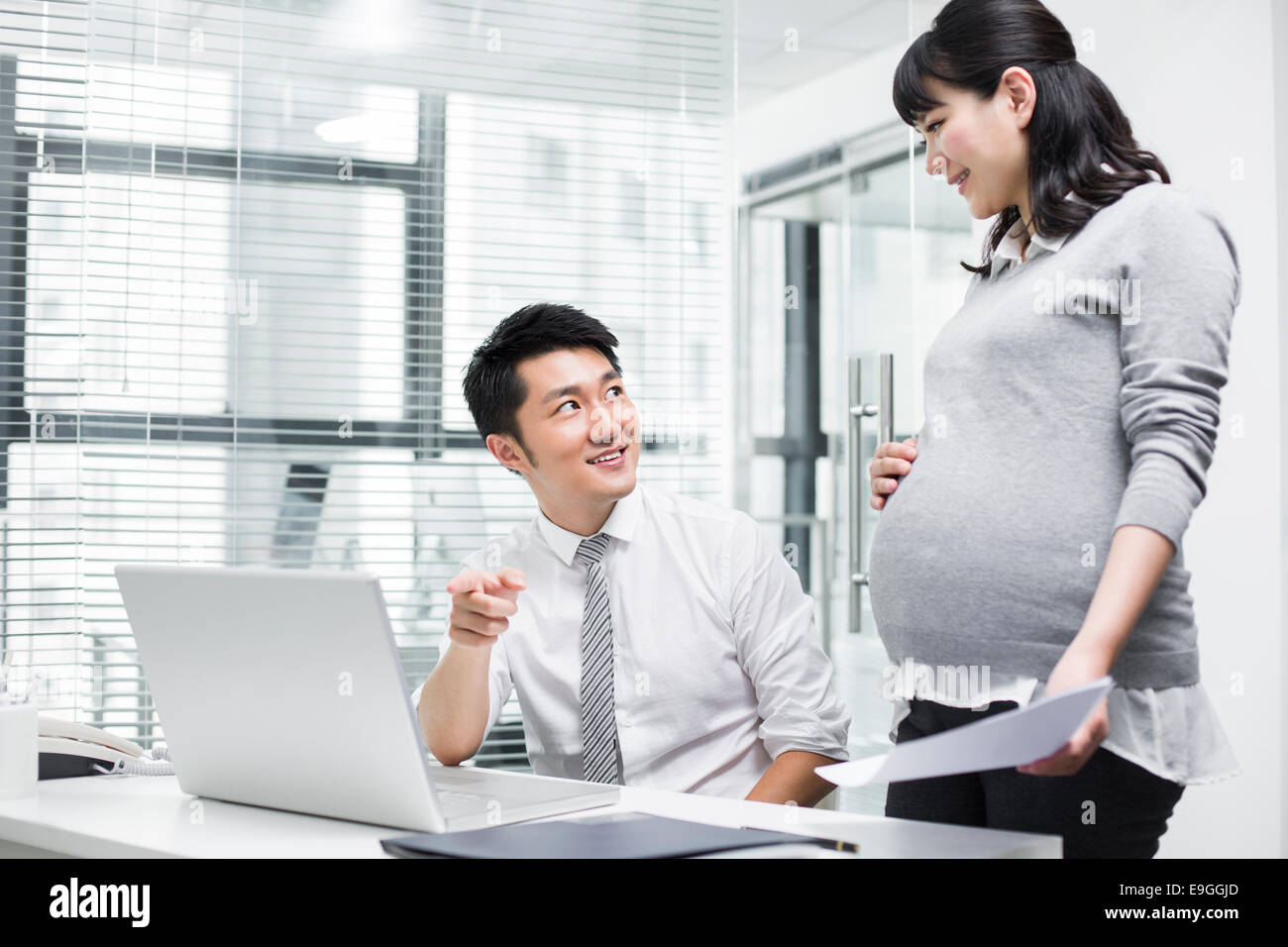 Pregnant businesswoman working with colleague Stock Photo - Alamy