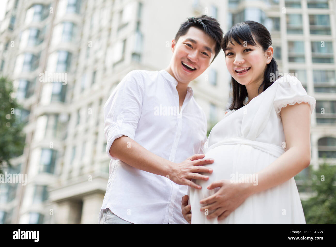 Expectant couple touching baby bump Stock Photo - Alamy