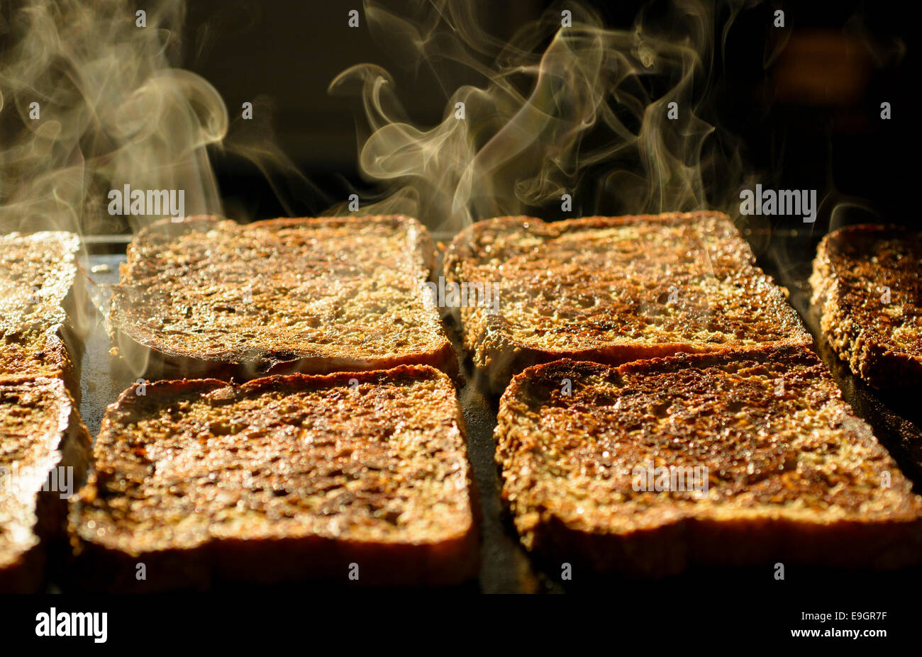Steamy hot French toast with cinnamon being fried on a griddle pan ...
