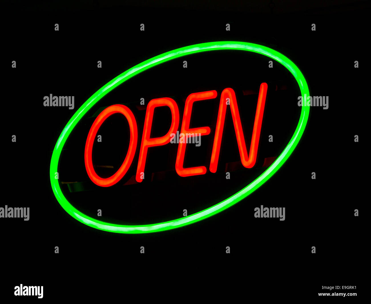 Illuminated neon open sign outside lit up at night on a shop window to ...