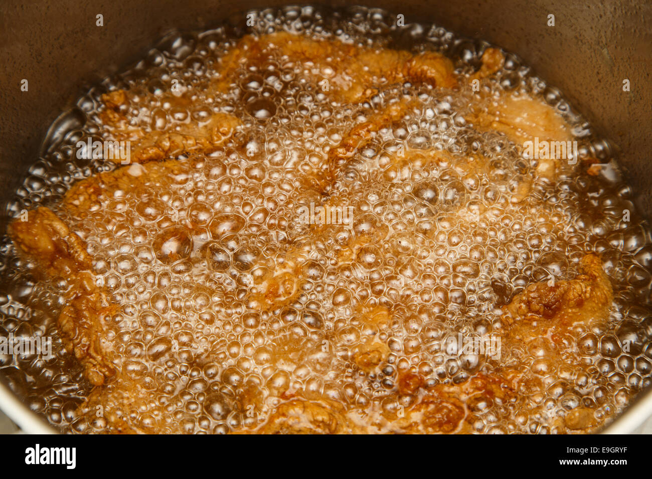 Chicken being deep fried in hot oil Stock Photo - Alamy
