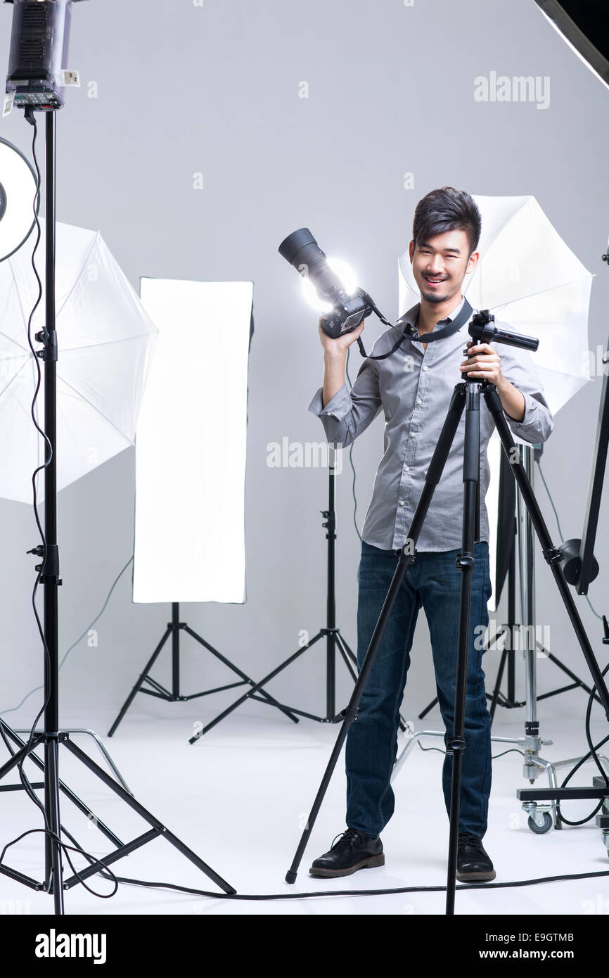 Photographer standing in studio with camera Stock Photo - Alamy