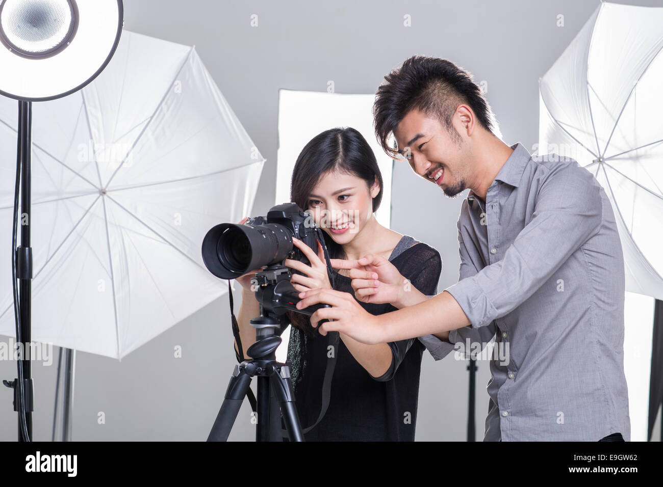 Two photographers working in studio Stock Photo - Alamy