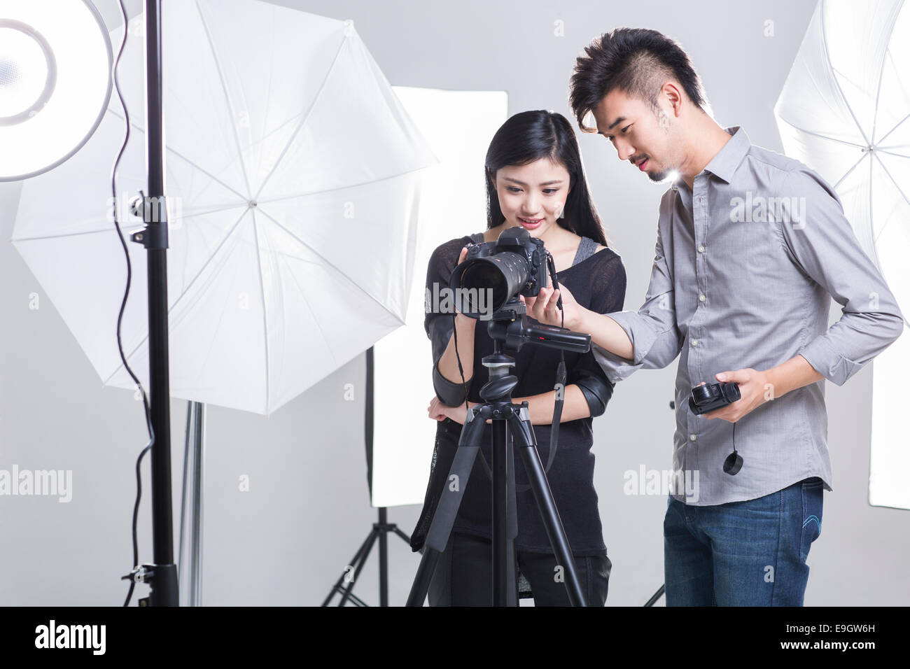 Two photographers working in studio Stock Photo - Alamy