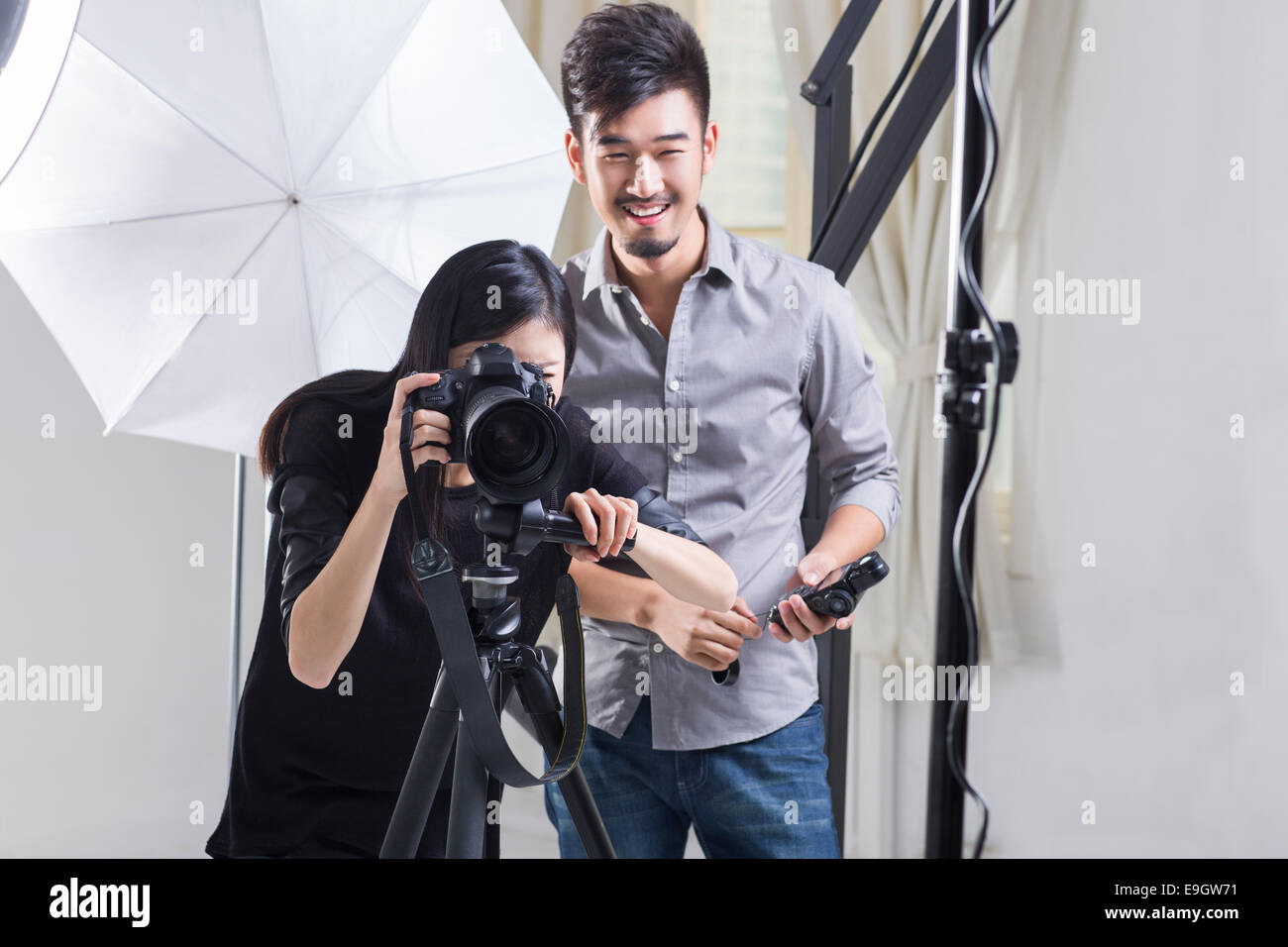 Two photographers working in studio Stock Photo - Alamy