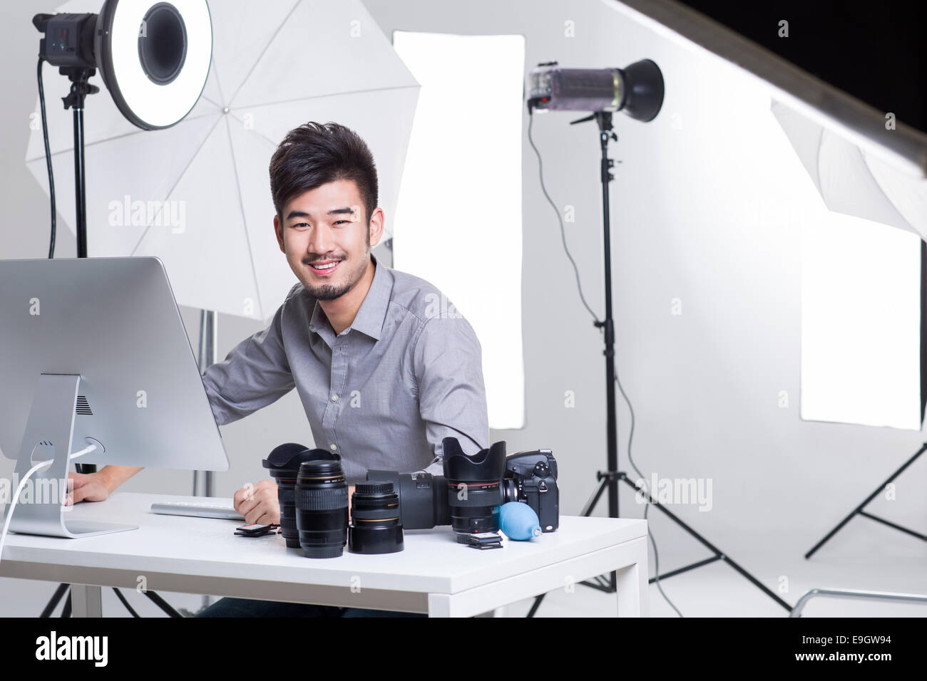 Portrait of photographer in studio with computer Stock Photo - Alamy