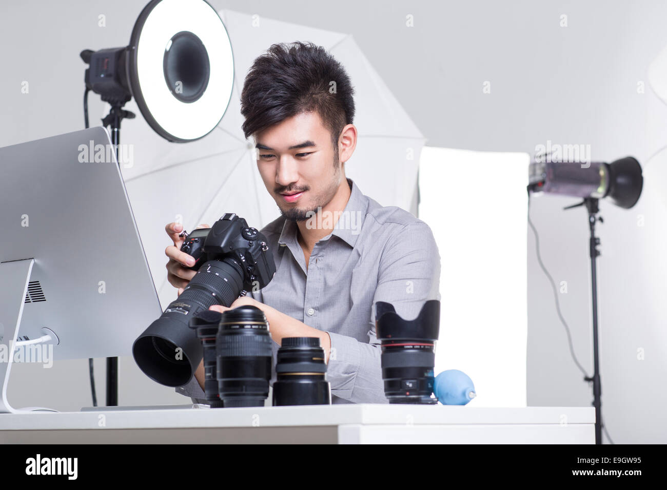 Photographer checking camera in studio Stock Photo - Alamy