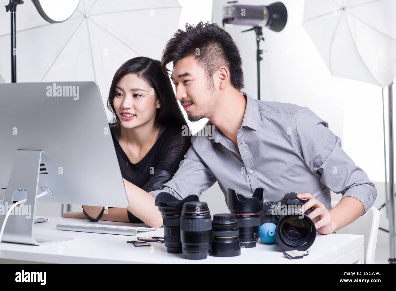 Two photographers working in studio with computer Stock Photo - Alamy
