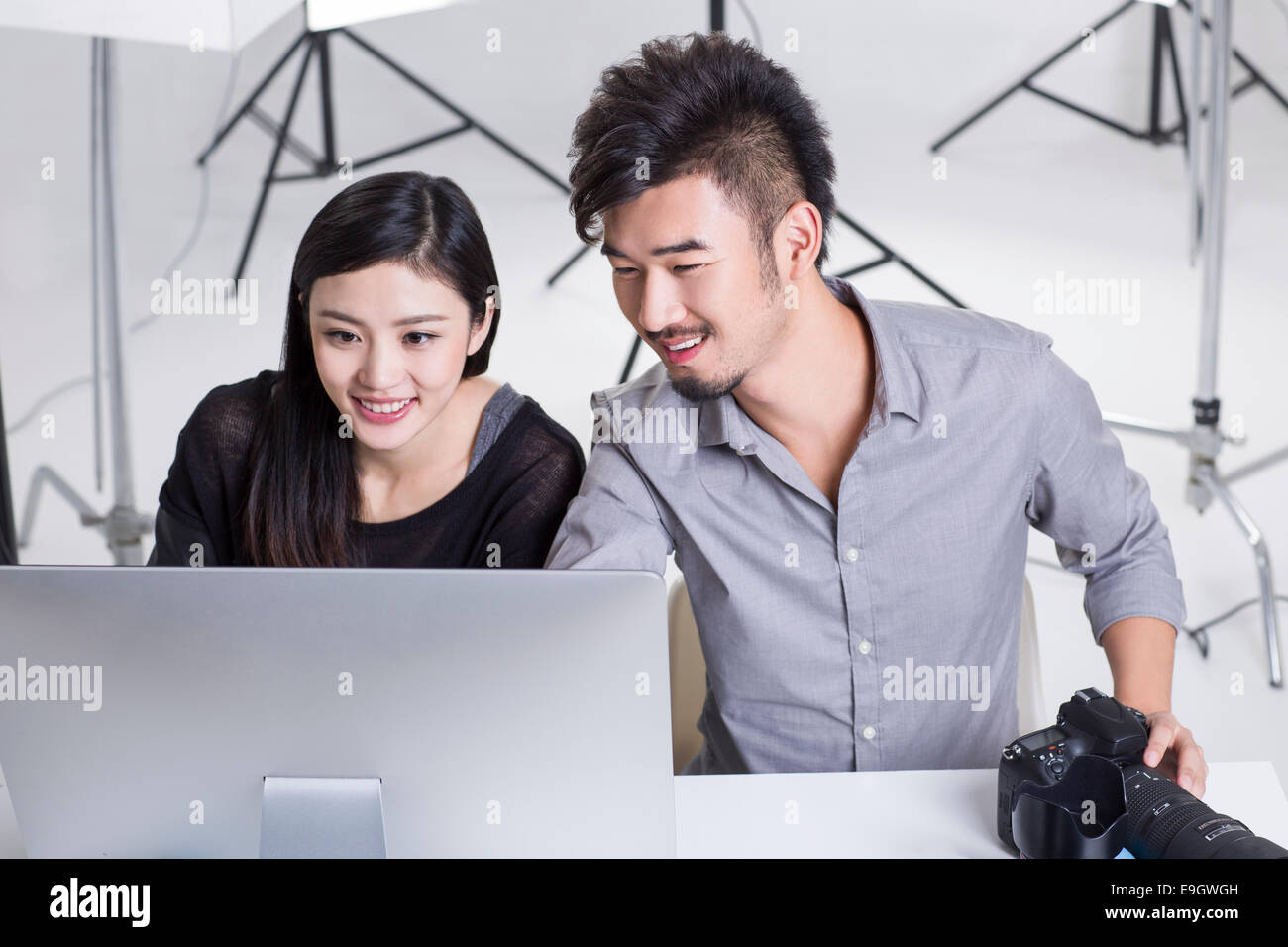Two photographers working in studio with computer Stock Photo - Alamy