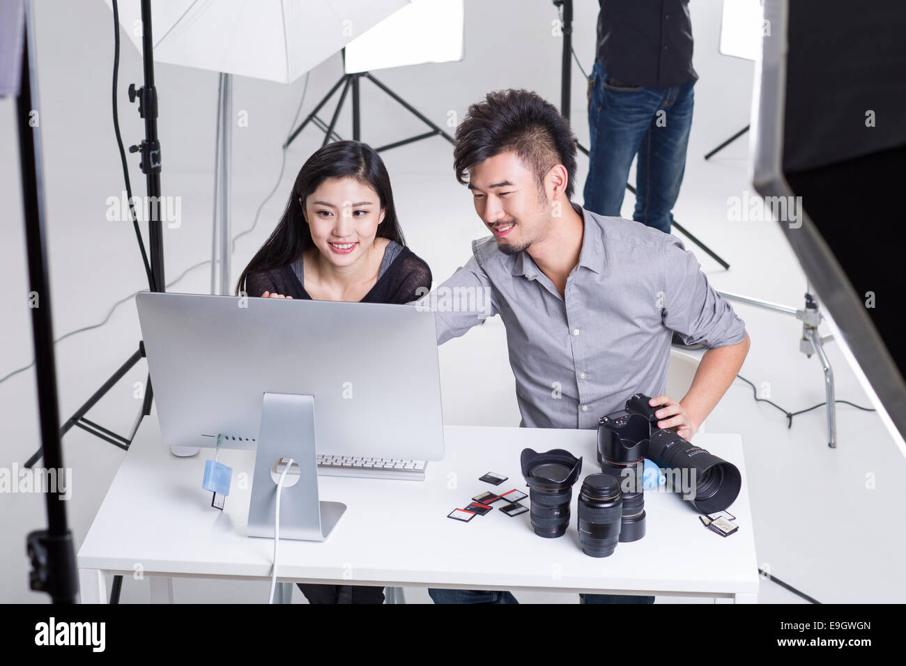 Two photographers working in studio with computer Stock Photo - Alamy