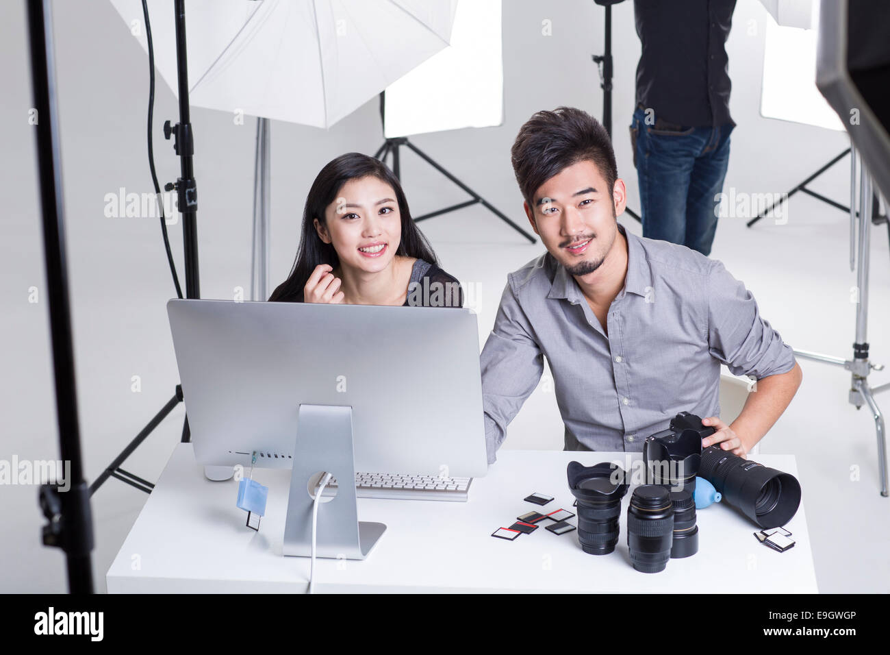 Two photographers working in studio with computer Stock Photo - Alamy