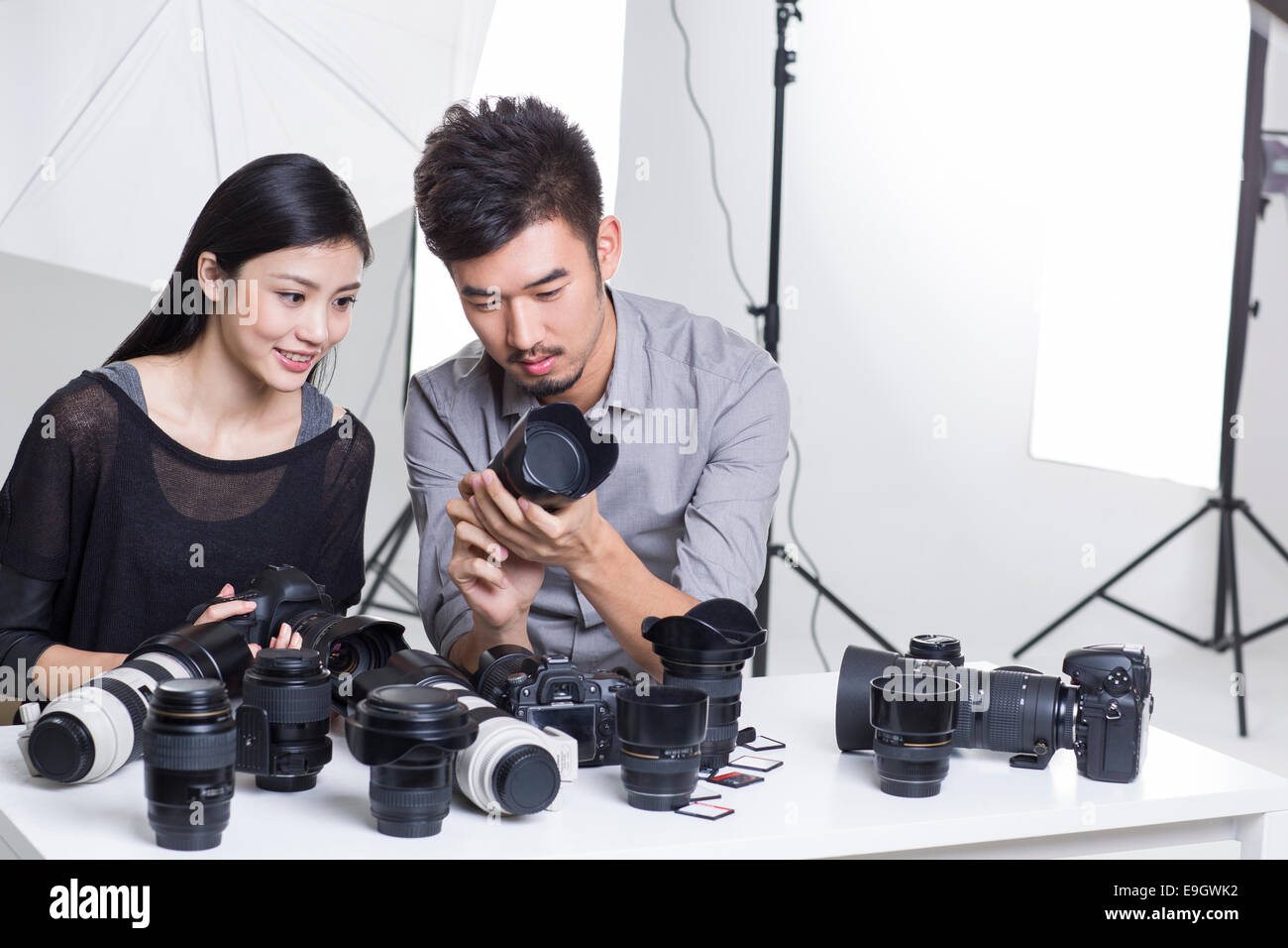 Two photographers working in studio Stock Photo - Alamy