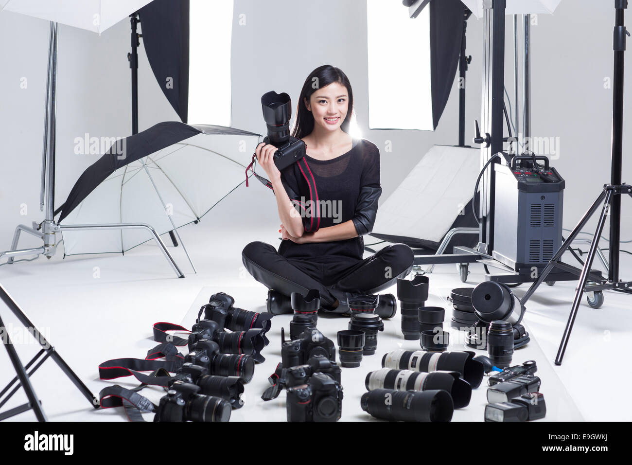 Photographer in studio with many cameras on the ground Stock Photo - Alamy