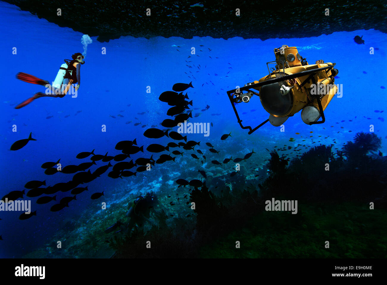 Scuba diver and a submarine in an underwater cave, composite image ...