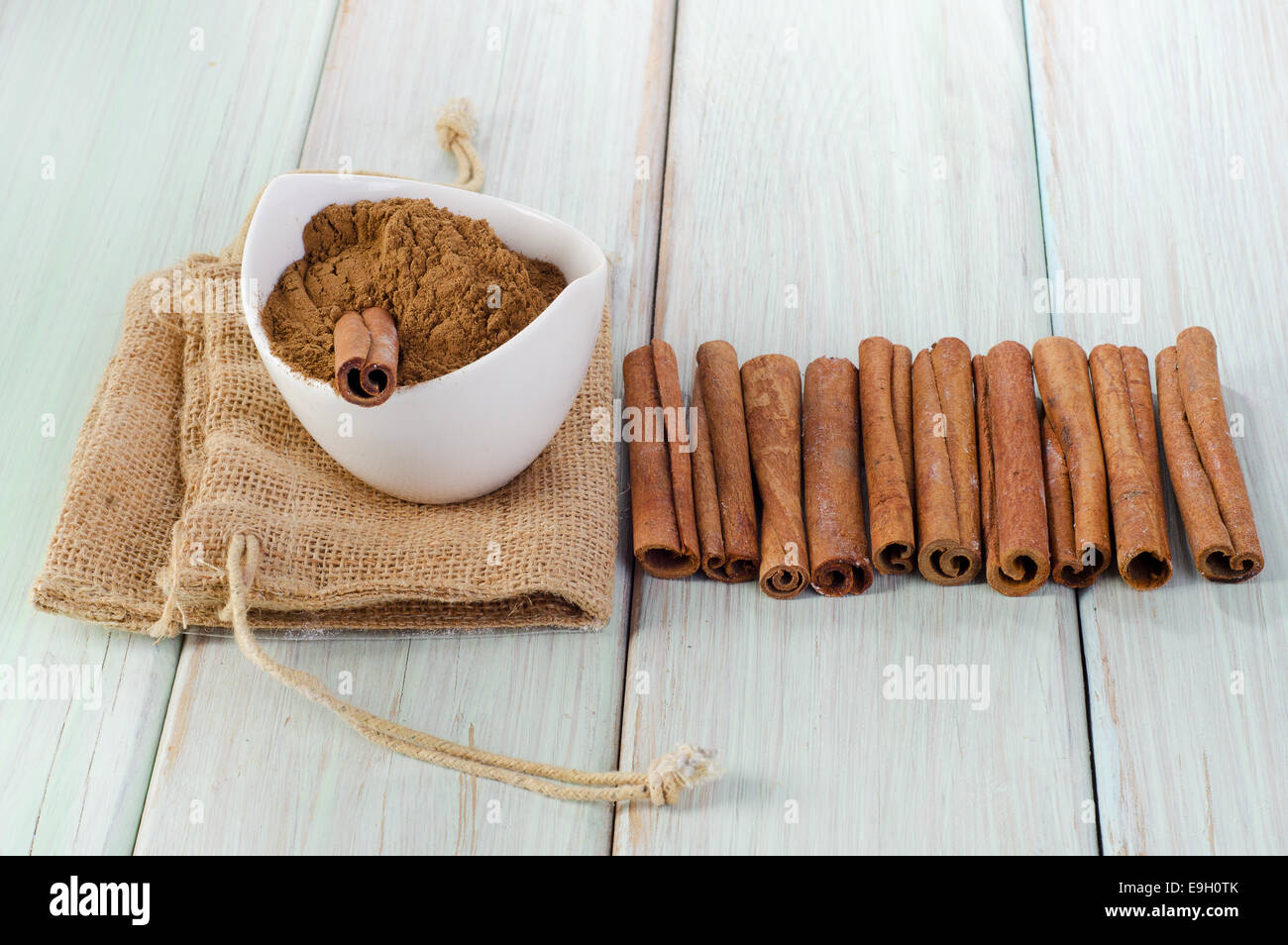 Cinnamon sticks and powder on wooden table Stock Photo - Alamy