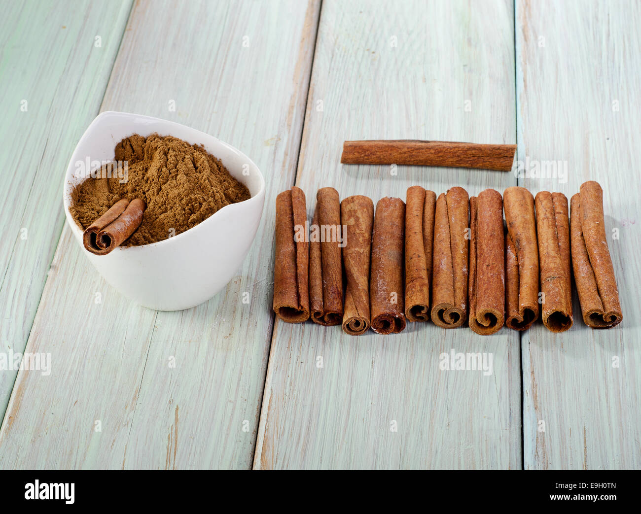 Cinnamon sticks and powder on wooden table Stock Photo - Alamy
