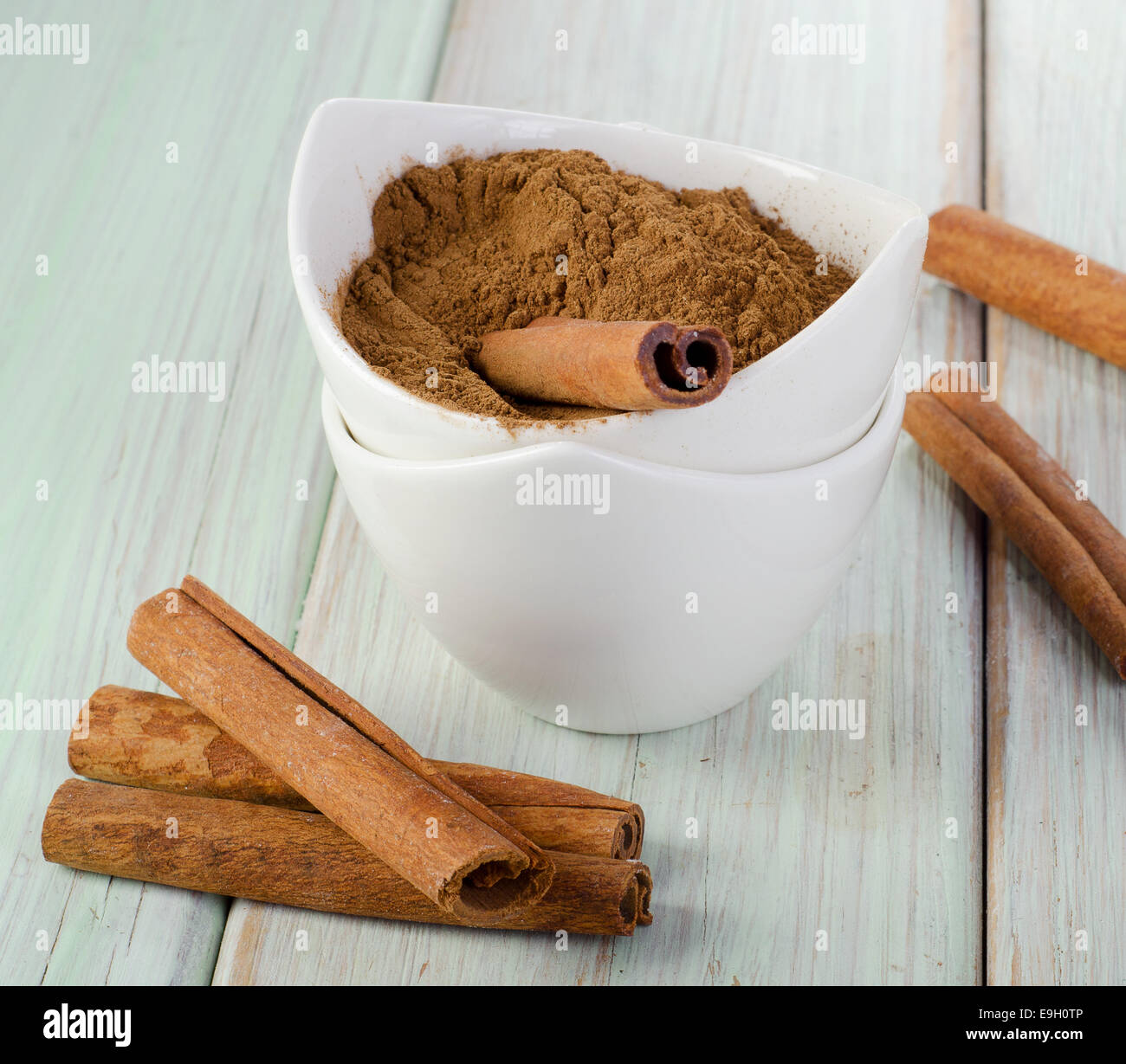 Cinnamon sticks and powder on wooden table Stock Photo - Alamy