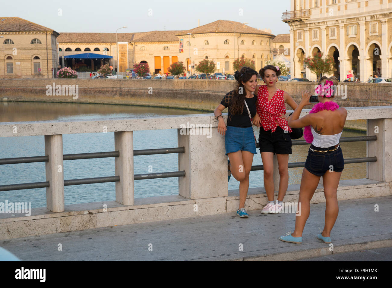 Women posing on the bridge crossing the Nevole River during the Summer ...