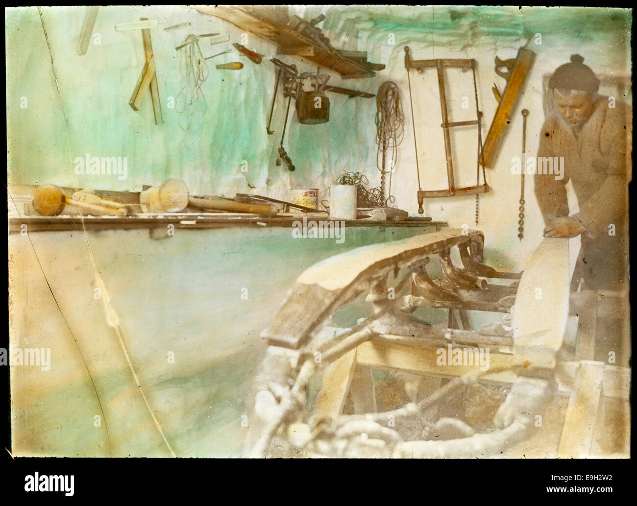 This image shows Olav Bjaaland working on a sled in a workshop dug out ...