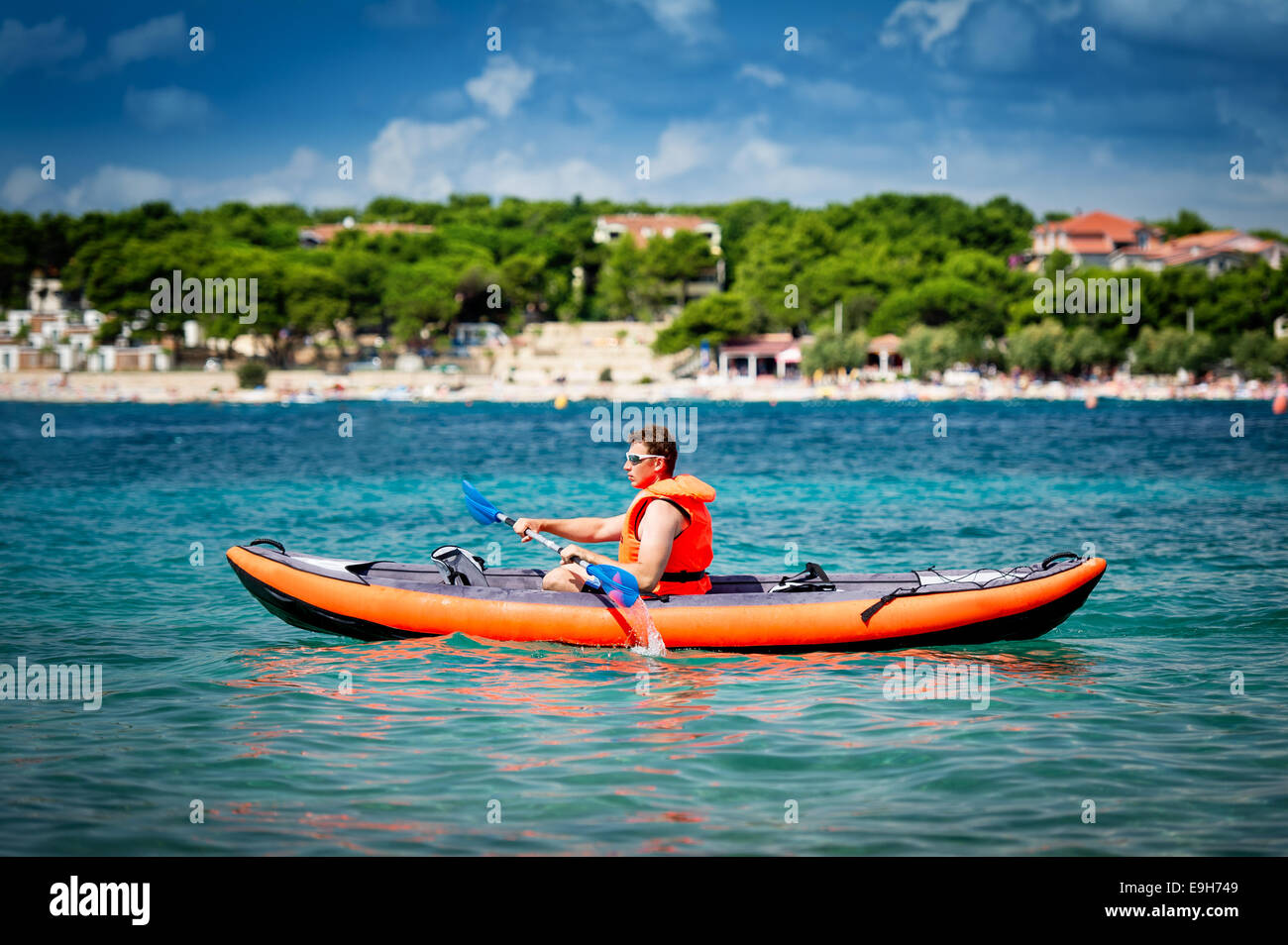 Young men paddle a kayak on the sea Stock Photo - Alamy