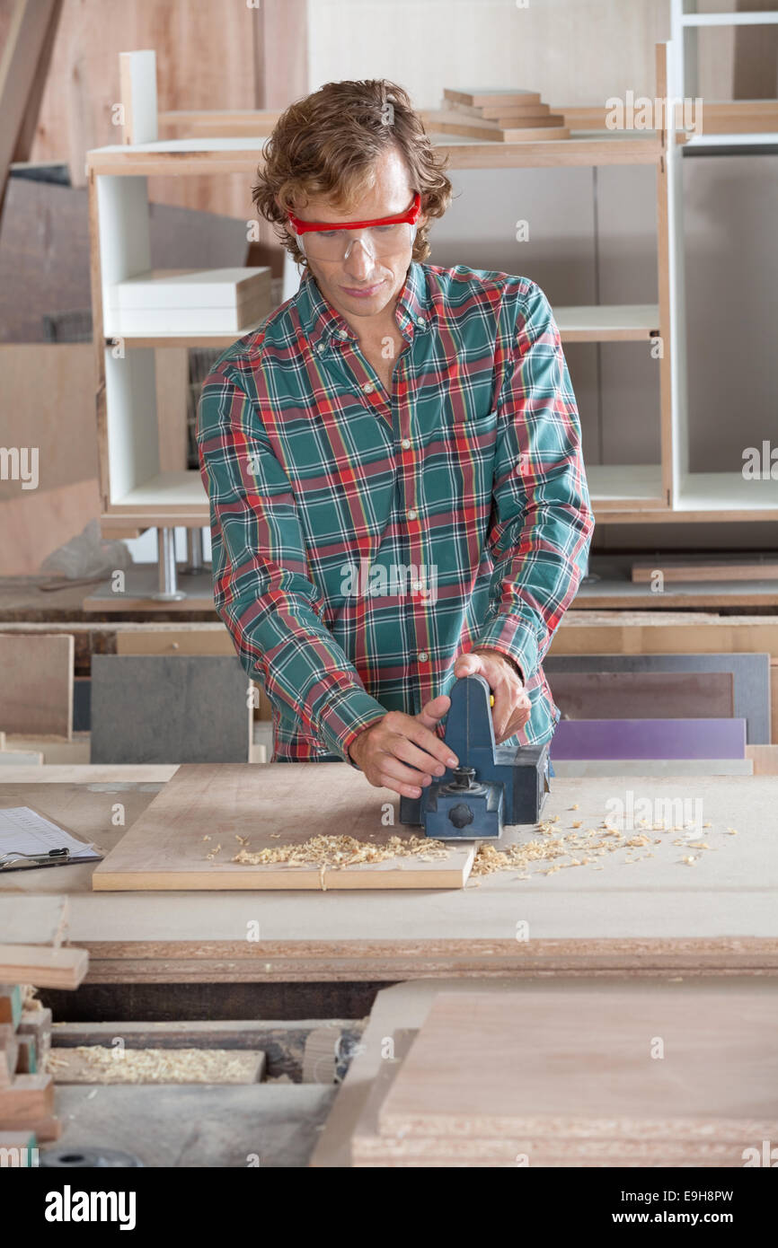 Carpenter Using Electric Planer On Wood Stock Photo - Alamy