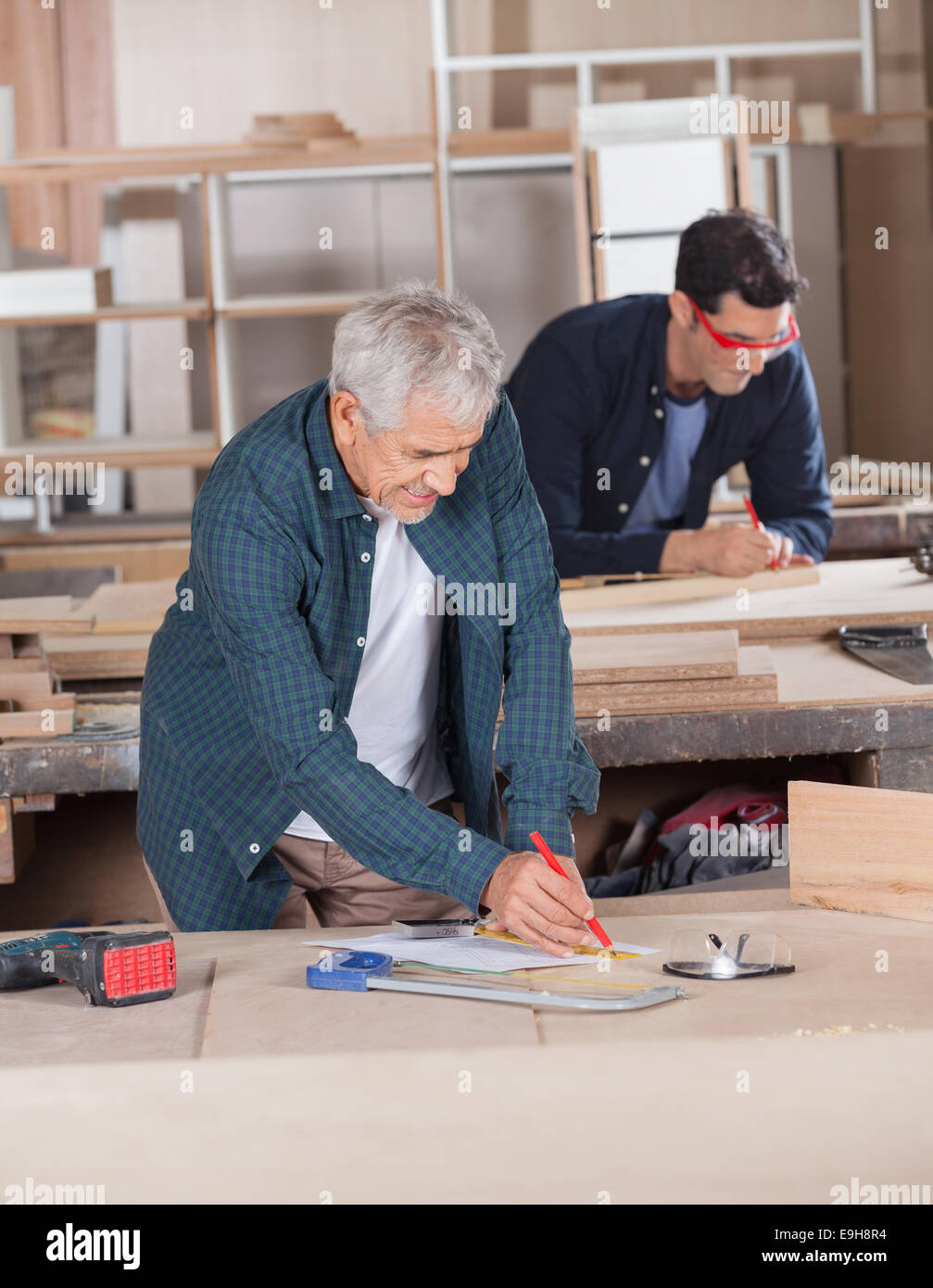 Male Carpenter Working On Blueprint At Workshop Stock Photo - Alamy