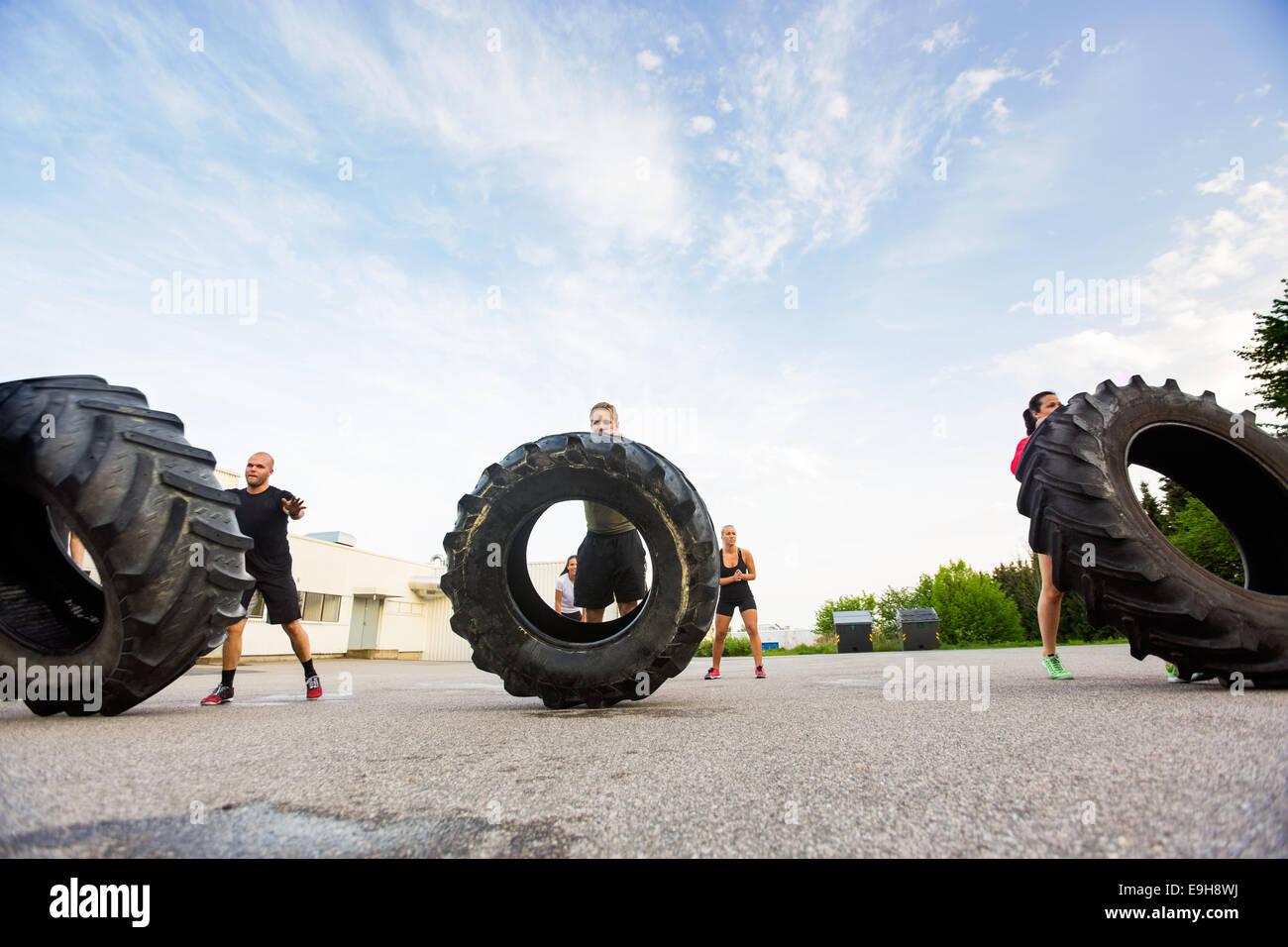 Athletes Doing Tire-Flip Exercise Stock Photo - Alamy