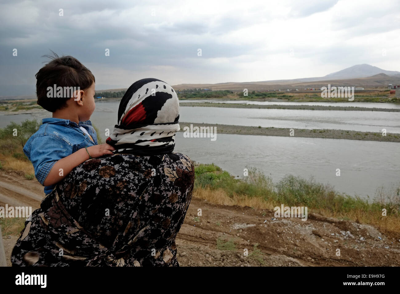A Kurdish mother and her child gazing from the Syrian side of the ...