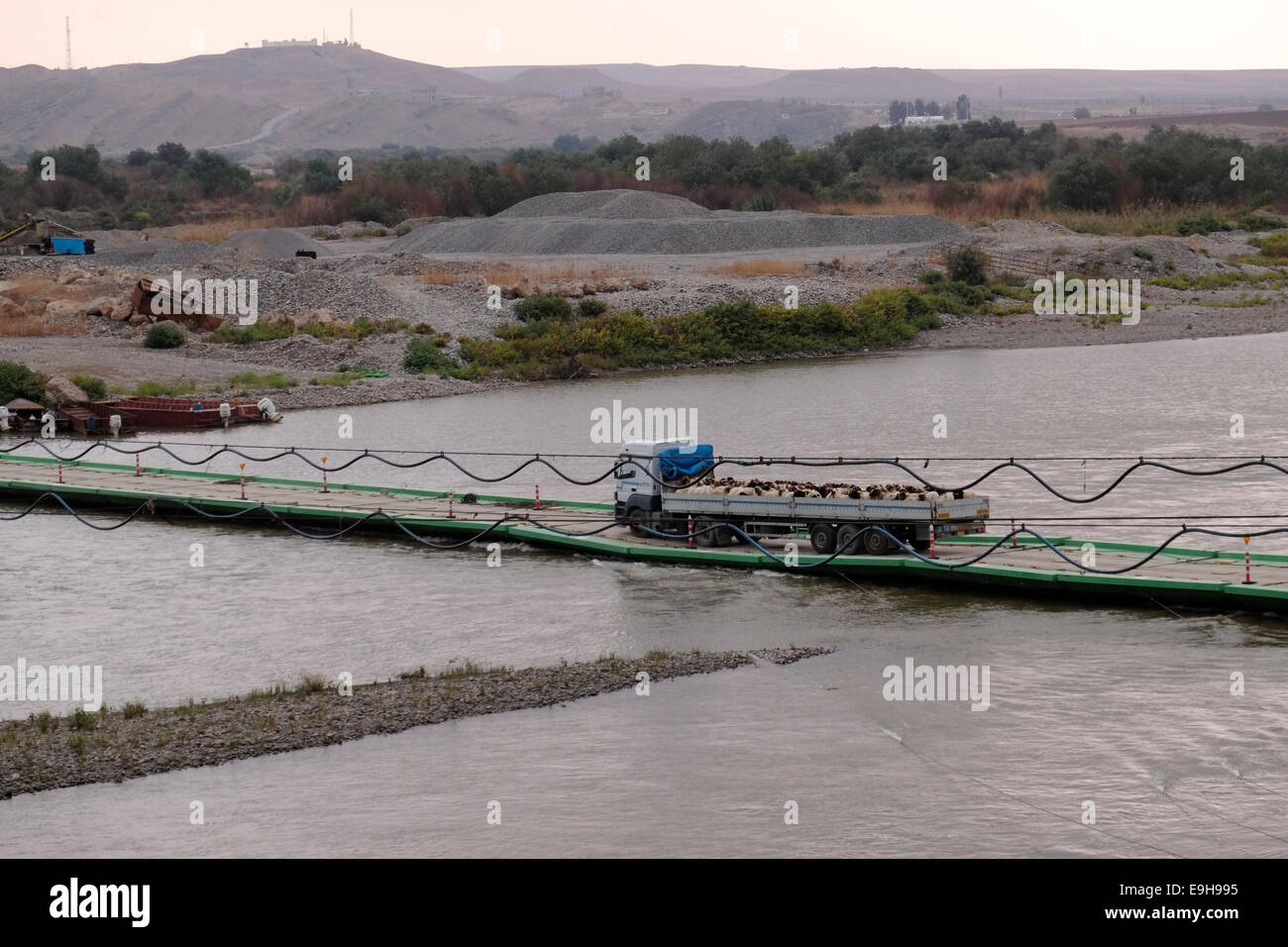 A truck loaded with sheep crossing a pontoon bridge over the Tigris ...