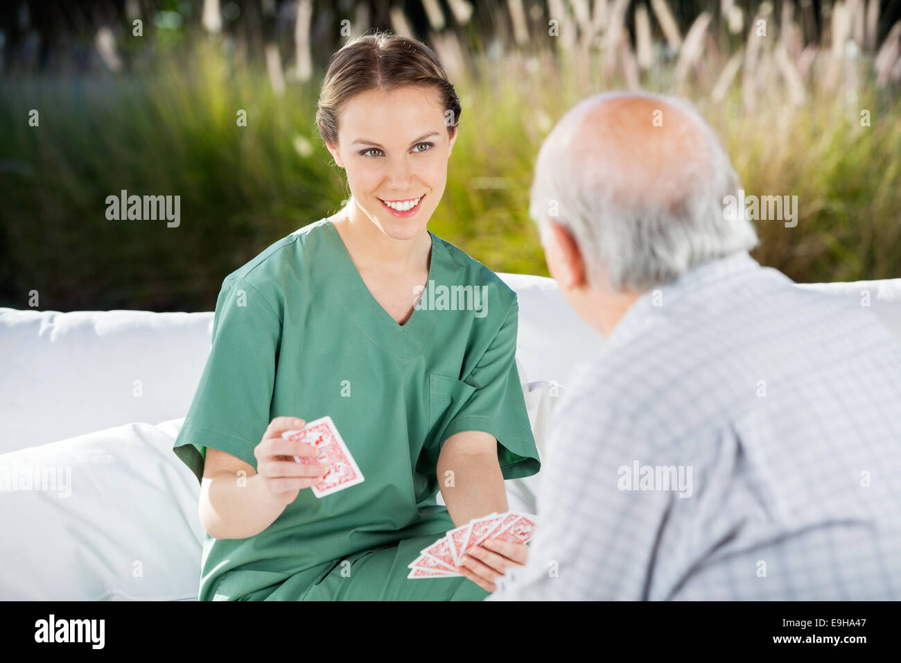 Smiling Female Nurse Playing Cards With Senior Man Stock Photo - Alamy