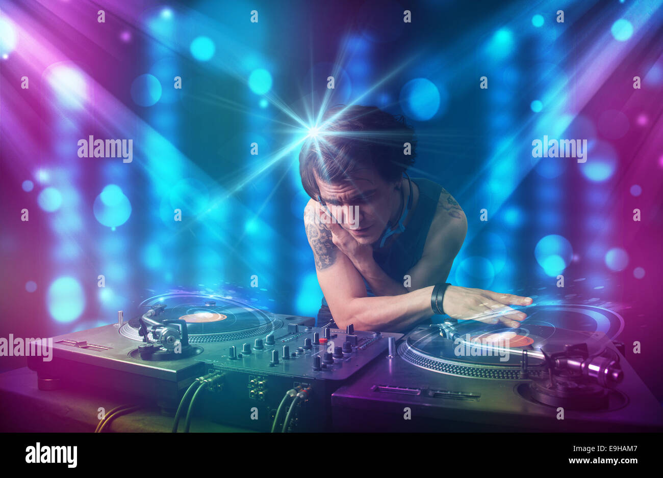 Dj mixing music in a club with blue and purple lights Stock Photo - Alamy