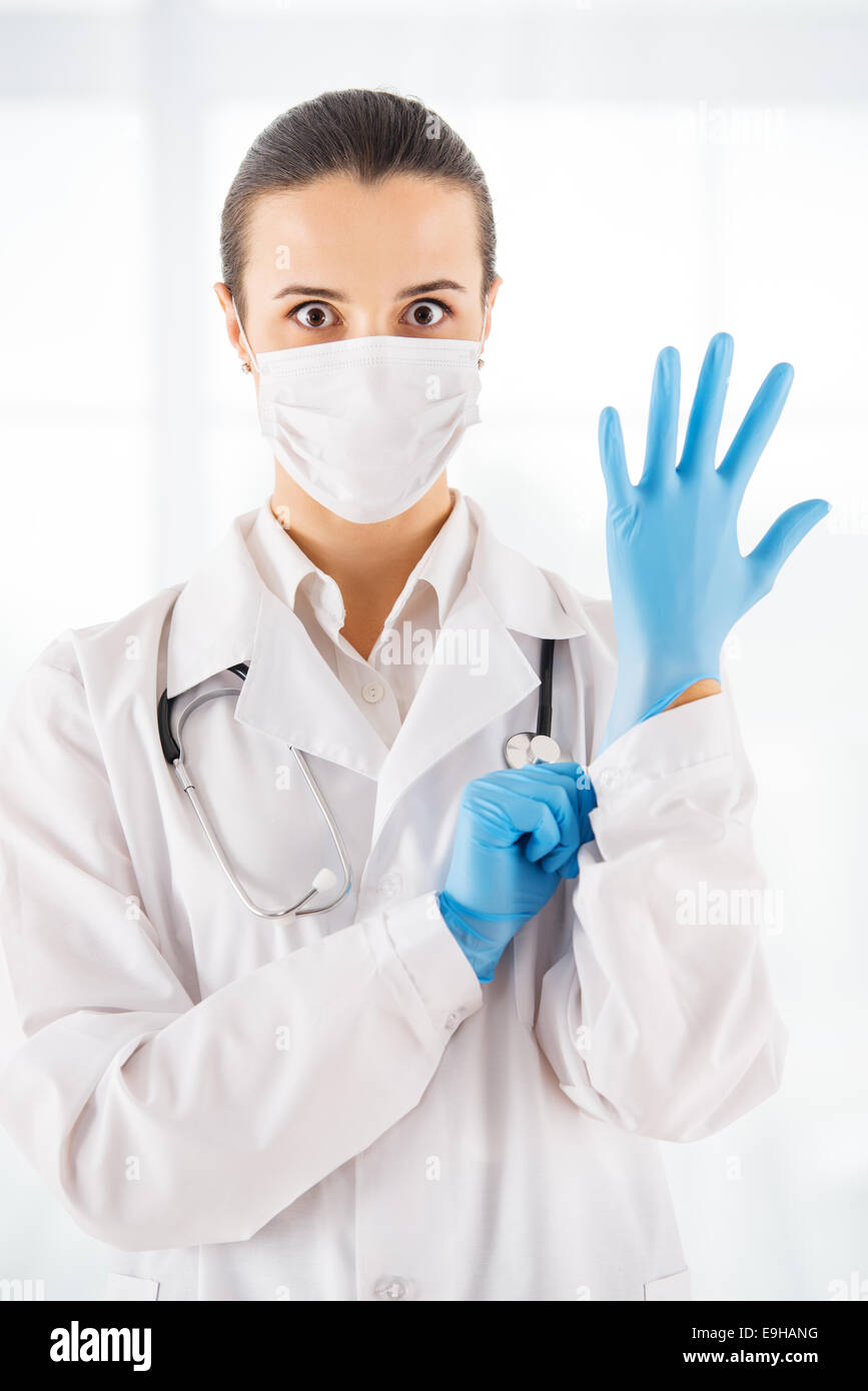 Doctor in gloves intently looking at camera Stock Photo - Alamy