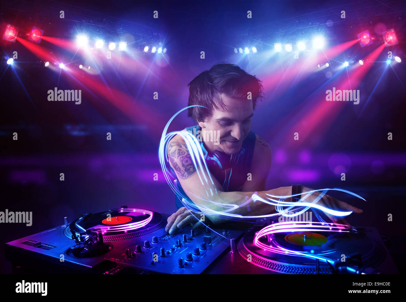 Disc jockey playing music with light beam effects on stage Stock Photo ...