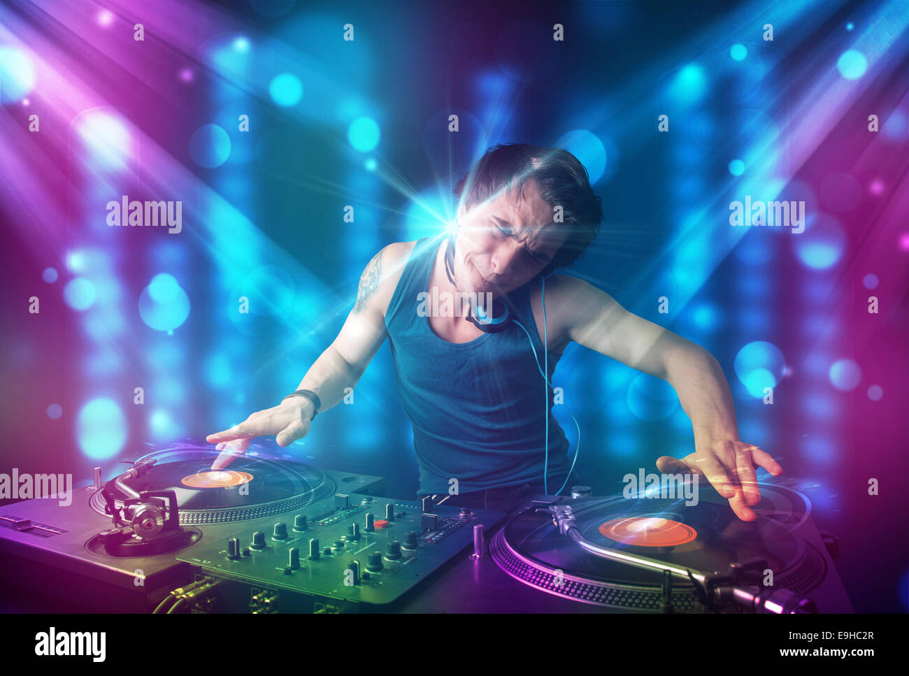 Dj mixing music in a club with blue and purple lights Stock Photo - Alamy
