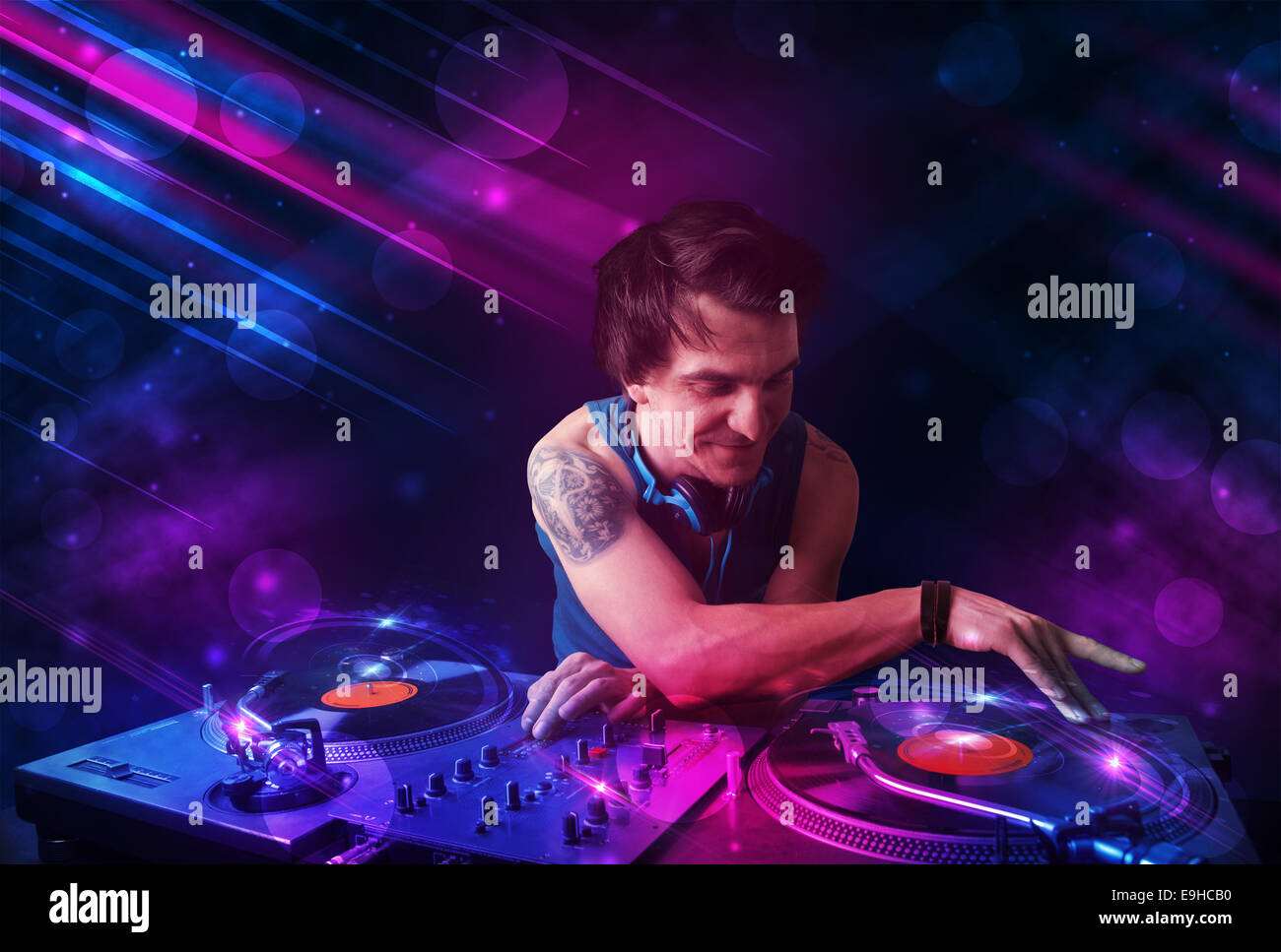 Young DJ playing on turntables with color light effects Stock Photo - Alamy