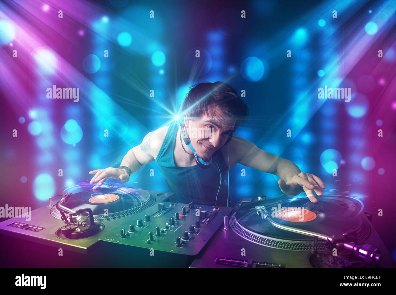 Dj mixing music in a club with blue and purple lights Stock Photo - Alamy