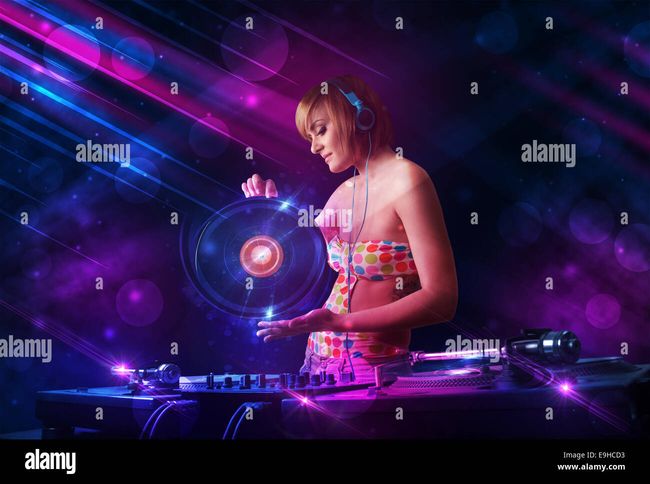 Young DJ playing on turntables with color light effects Stock Photo - Alamy