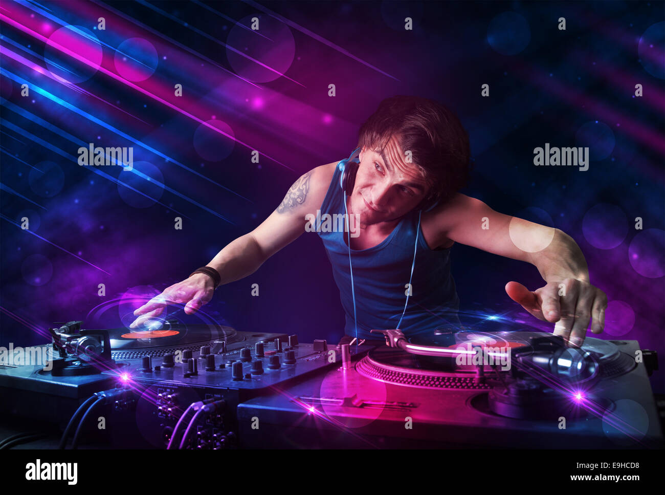 Young DJ playing on turntables with color light effects Stock Photo - Alamy