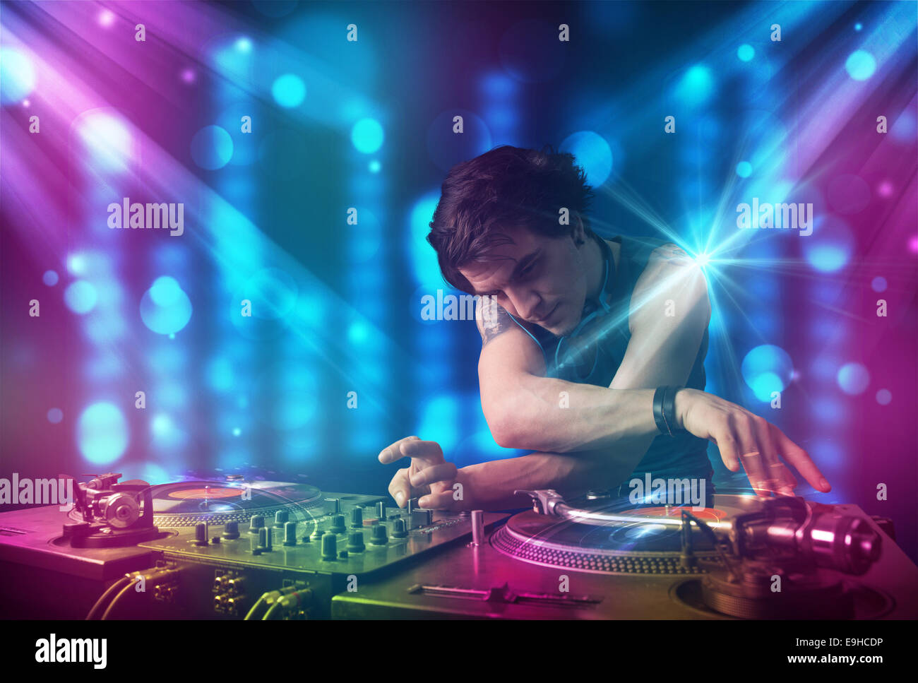 Dj mixing music in a club with blue and purple lights Stock Photo - Alamy