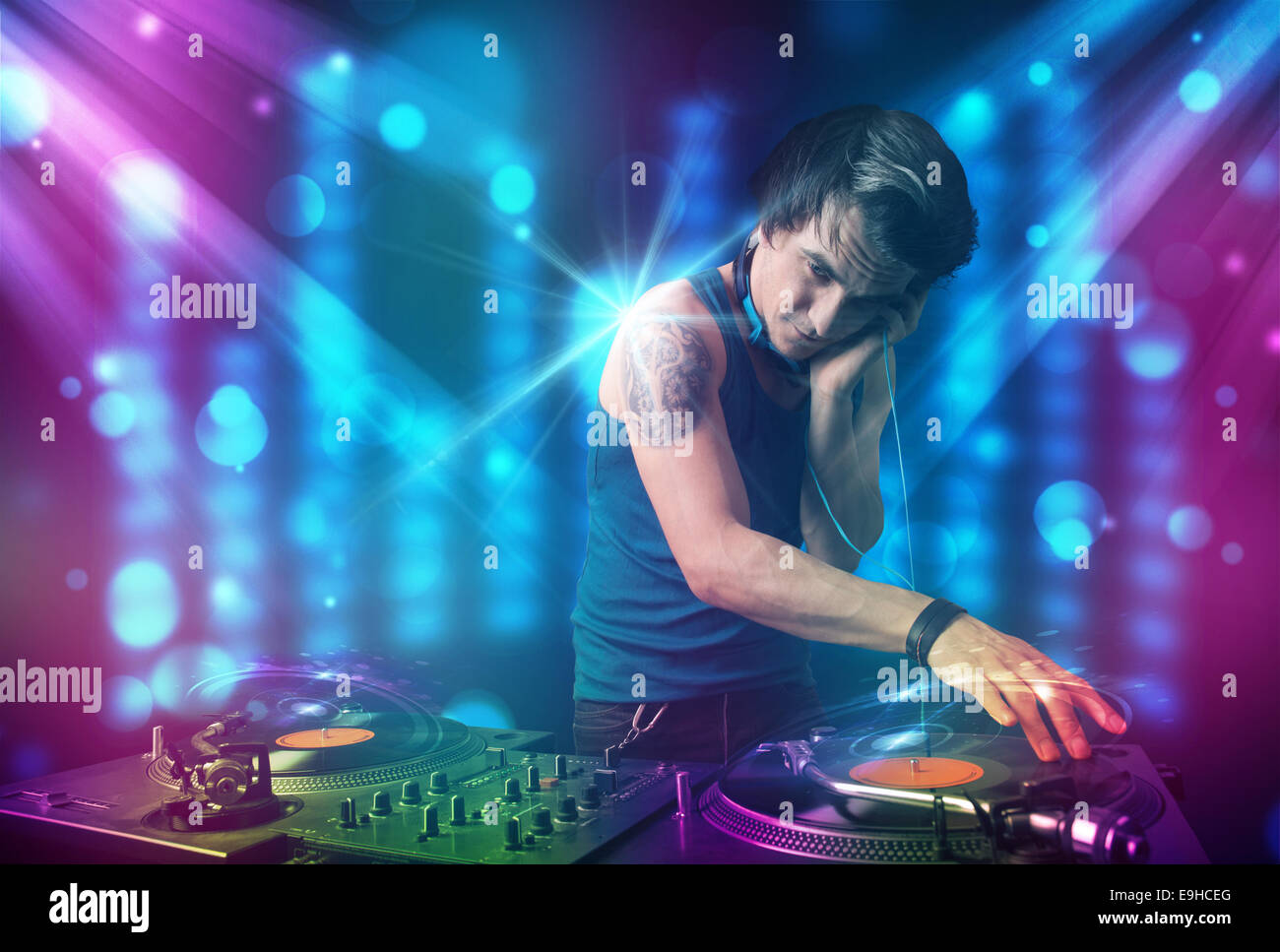 Dj mixing music in a club with blue and purple lights Stock Photo - Alamy