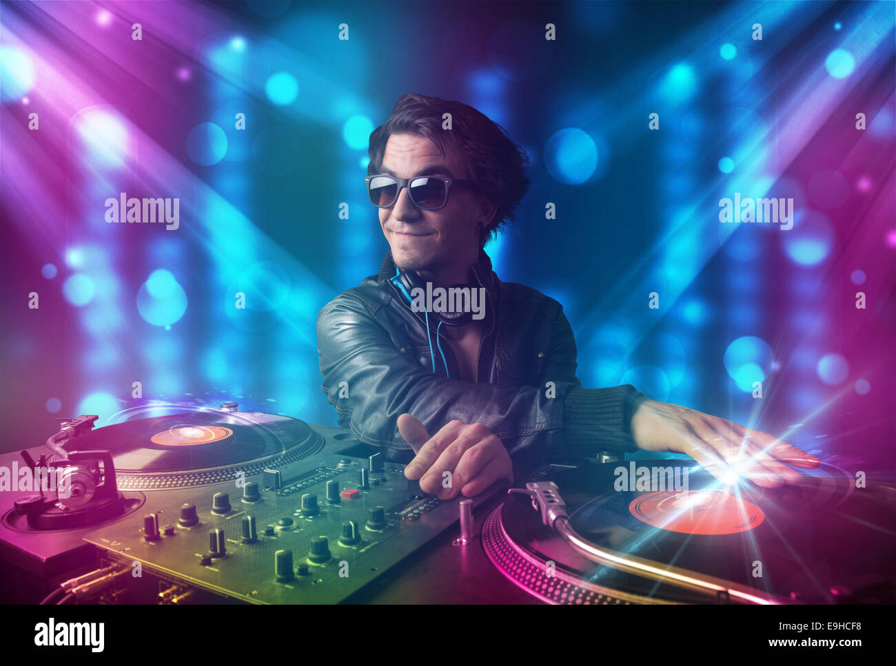 Dj mixing music in a club with blue and purple lights Stock Photo - Alamy