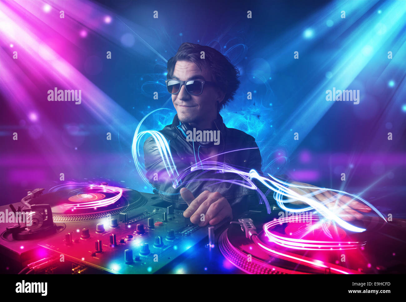 Energetic Dj mixing music with powerful light effects Stock Photo - Alamy