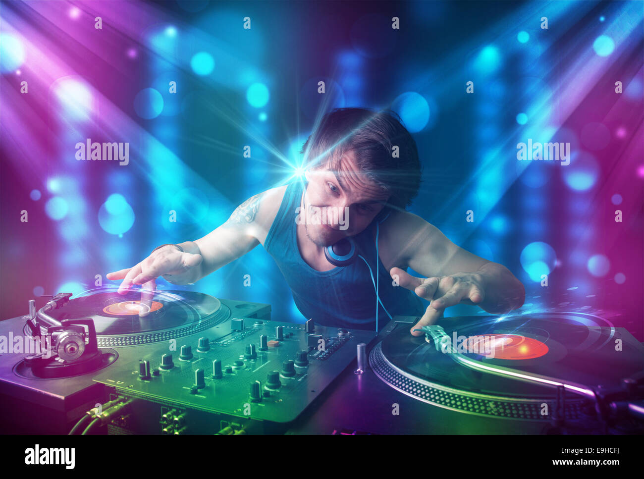 Dj mixing music in a club with blue and purple lights Stock Photo - Alamy