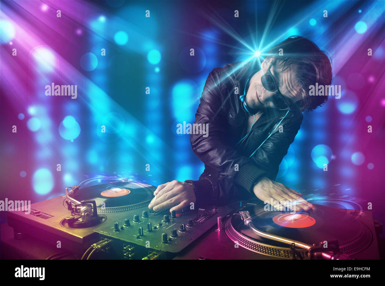 Dj mixing music in a club with blue and purple lights Stock Photo - Alamy